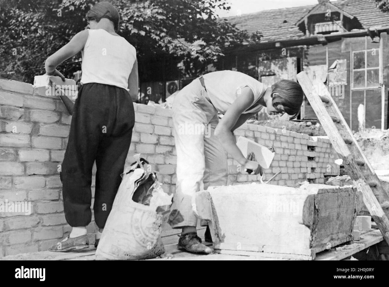 Two women bricklayers raising a wall in the USA. (undated photo ...