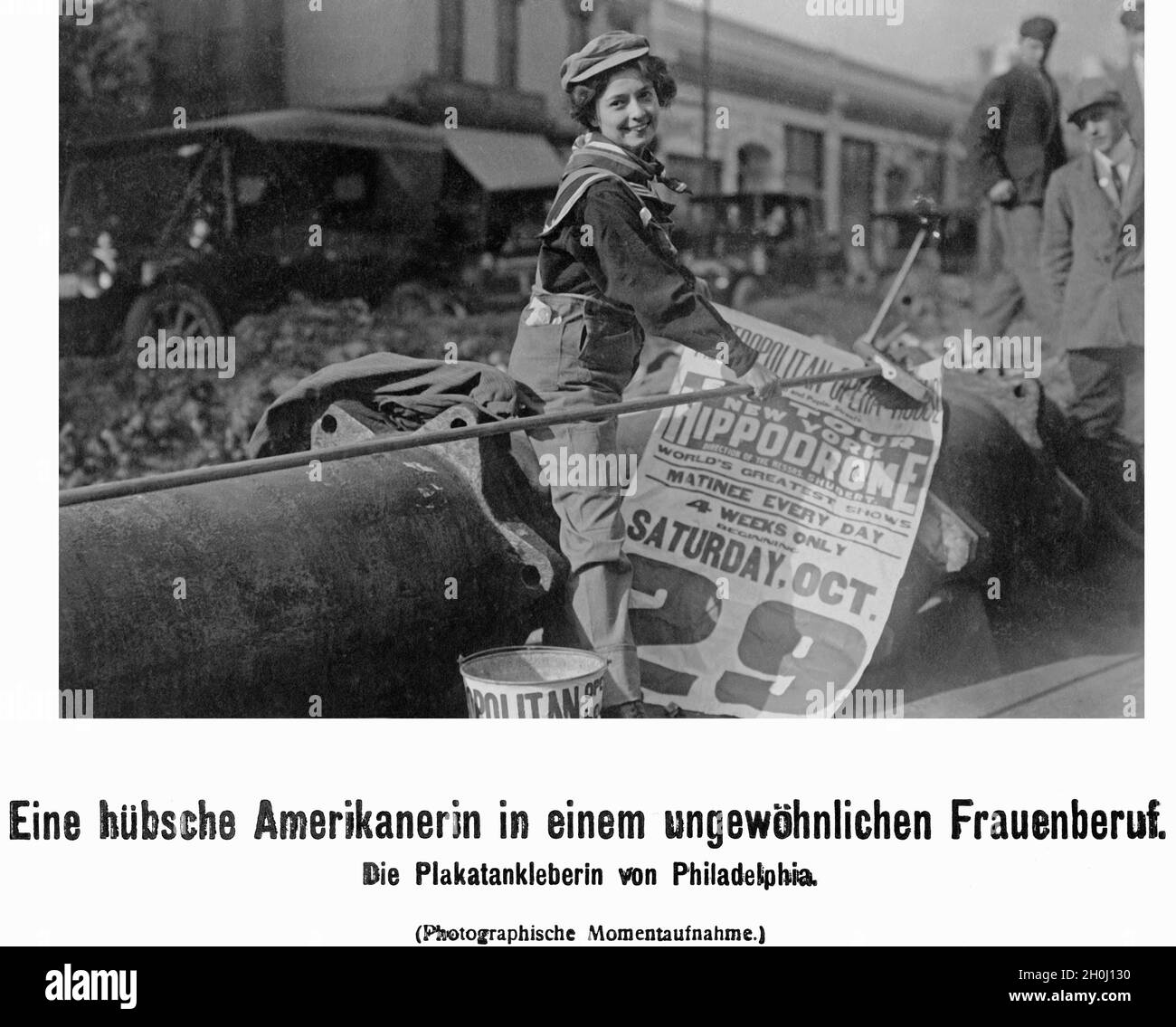 "A young woman pastes advertising posters for a tour of the ...