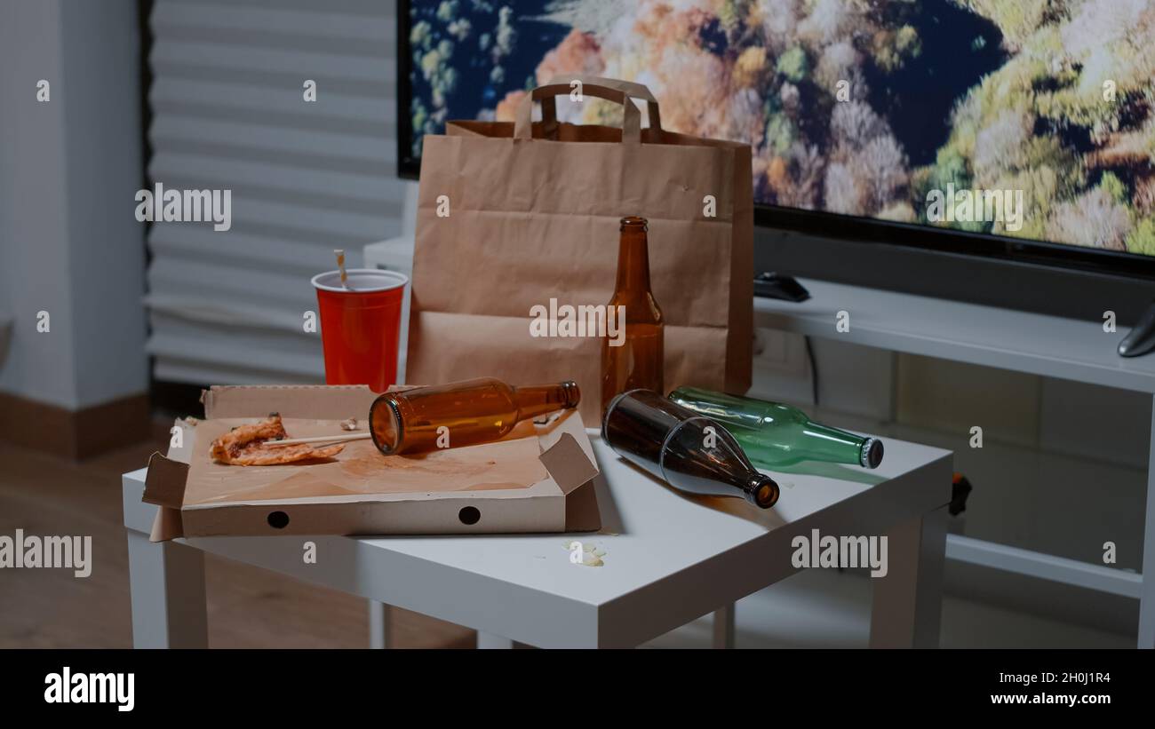 Messy table with empty beer bottles and food leftover on it placed in ...