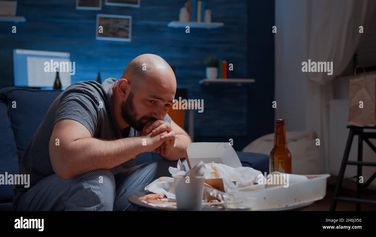 Lonely depressed traumatised man with tears sitting on couch crying ...