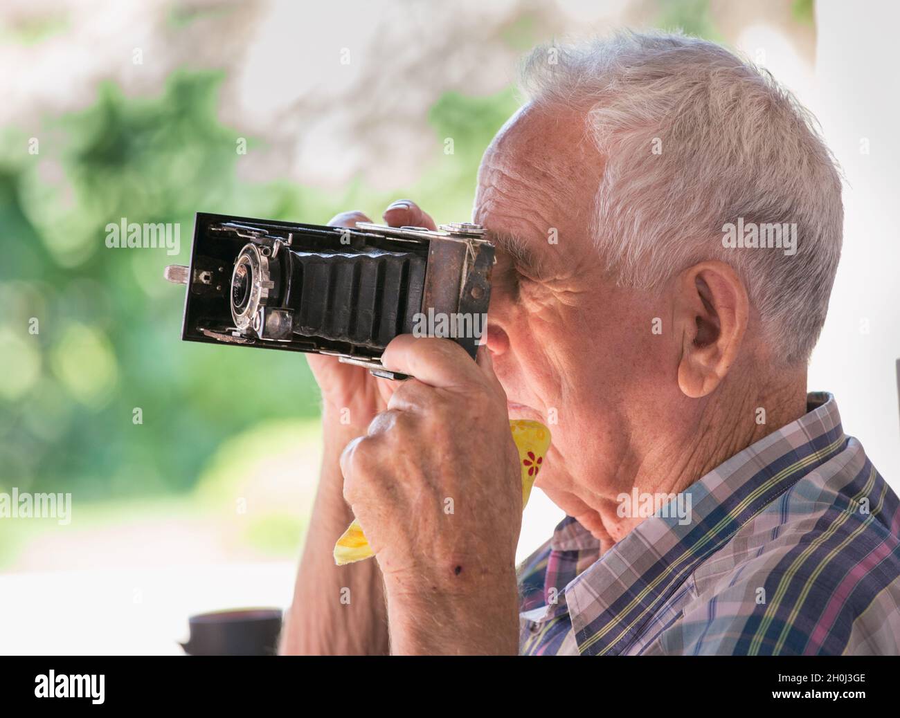 Senior man taking photos with old analog camera in park Stock Photo - Alamy