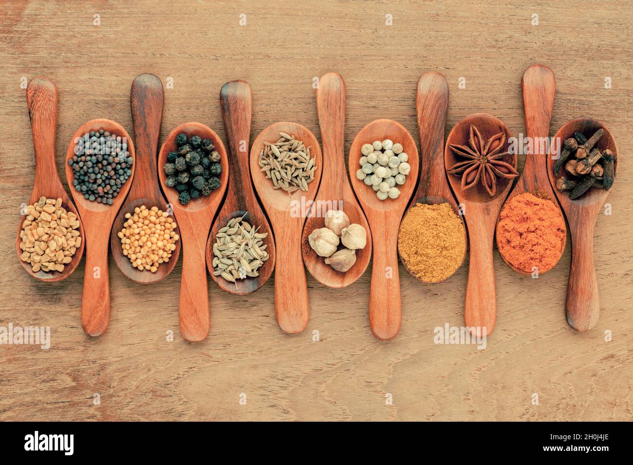 Assorted of spices in wooden spoon black pepper ,white pepper, black ...
