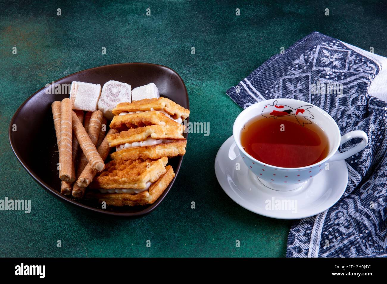 side view sweets waffles sweet rolls and marmalade with a cup of tea on ...