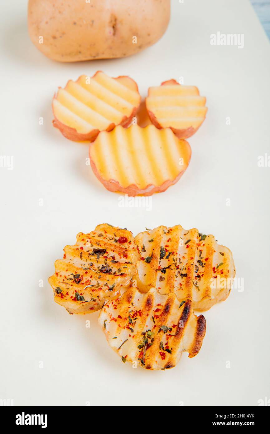 side view of whole sliced and fried potato on white background Stock ...