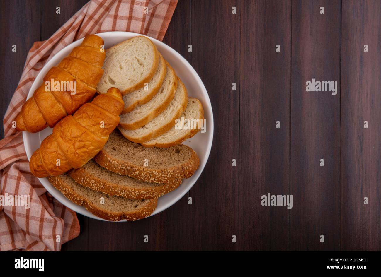 top view of breads as sliced seeded brown cob baguette and croissants ...