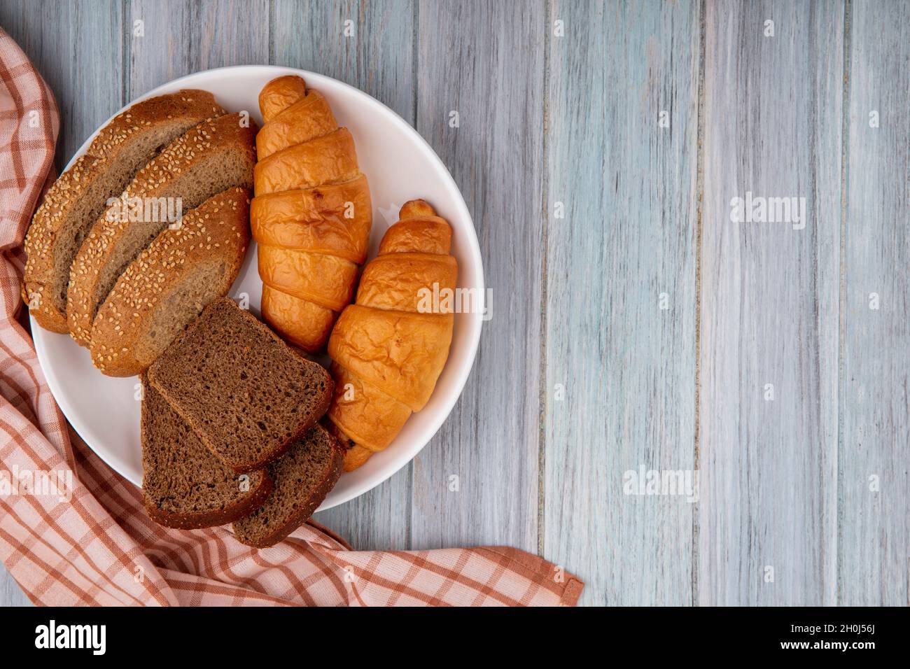 top view of breads as croissant sliced rye and seeded brown cob in ...