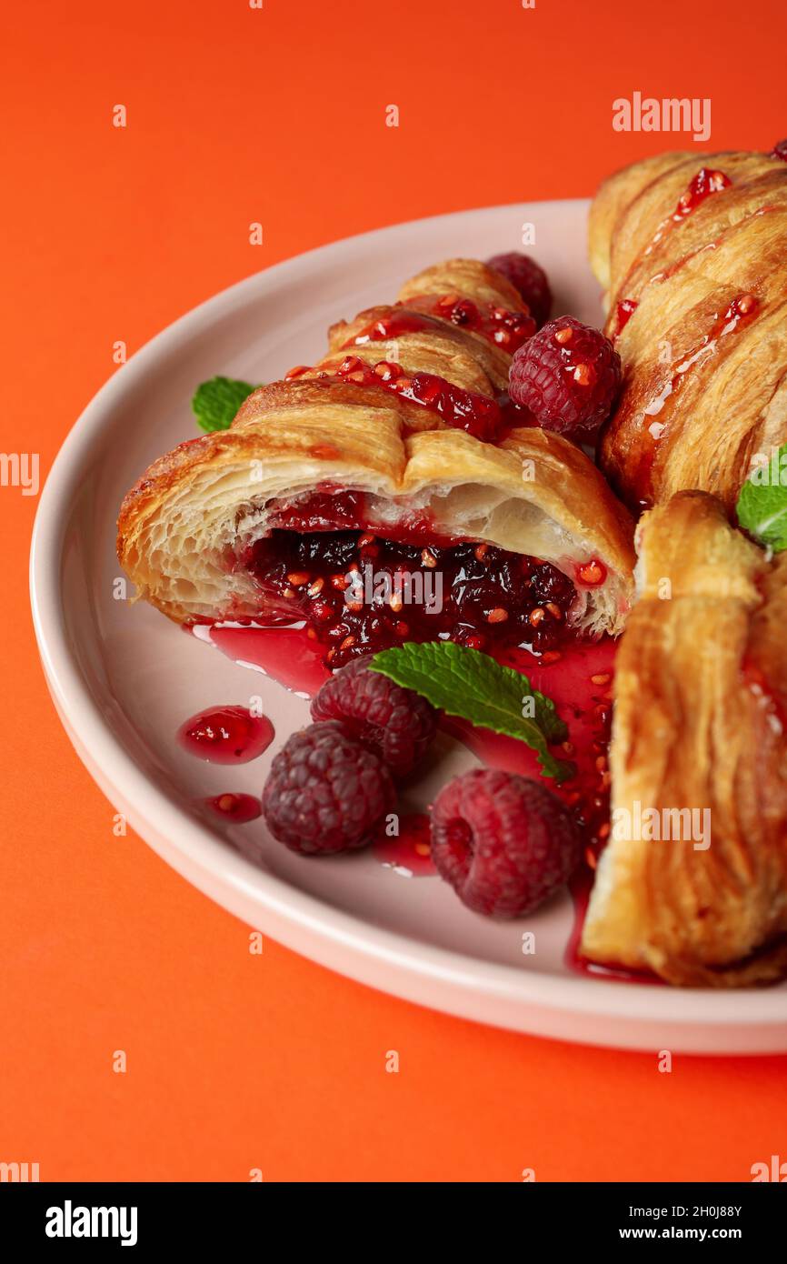 Plate with croissants with raspberry jam on orange background Stock ...