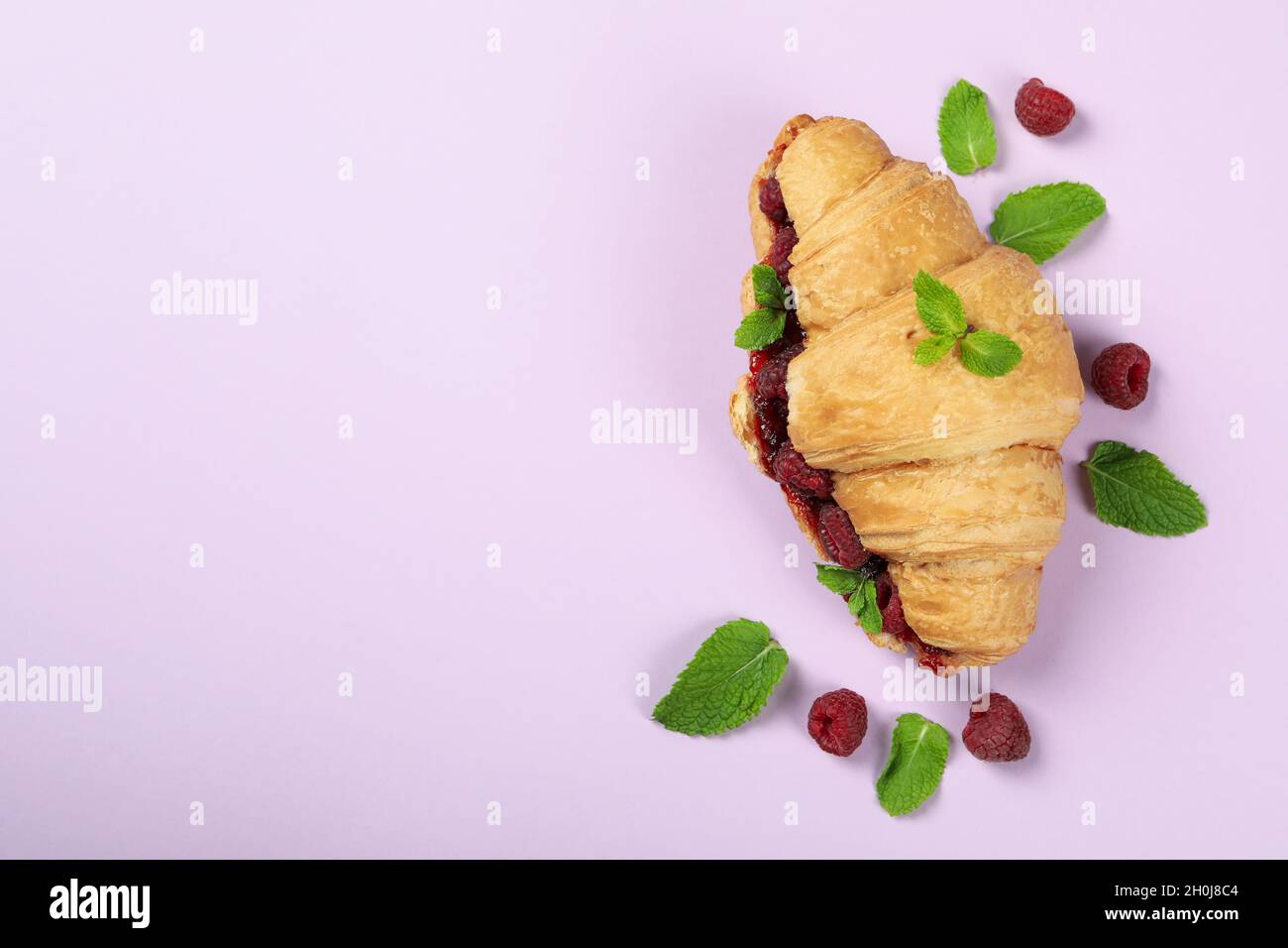 Croissant with raspberry jam on purple background Stock Photo - Alamy