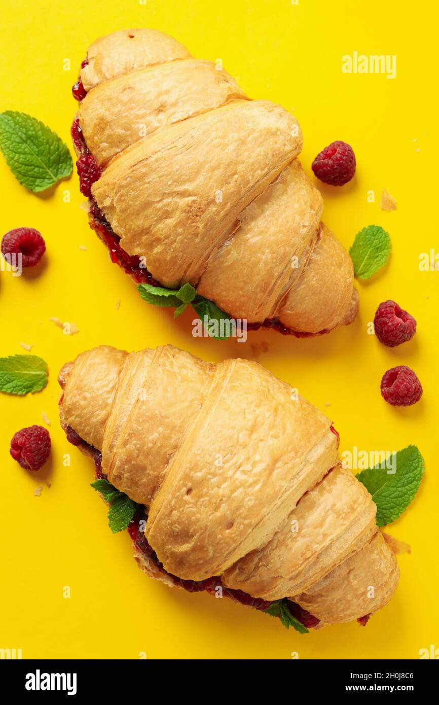 Croissants with raspberry jam on yellow background Stock Photo - Alamy