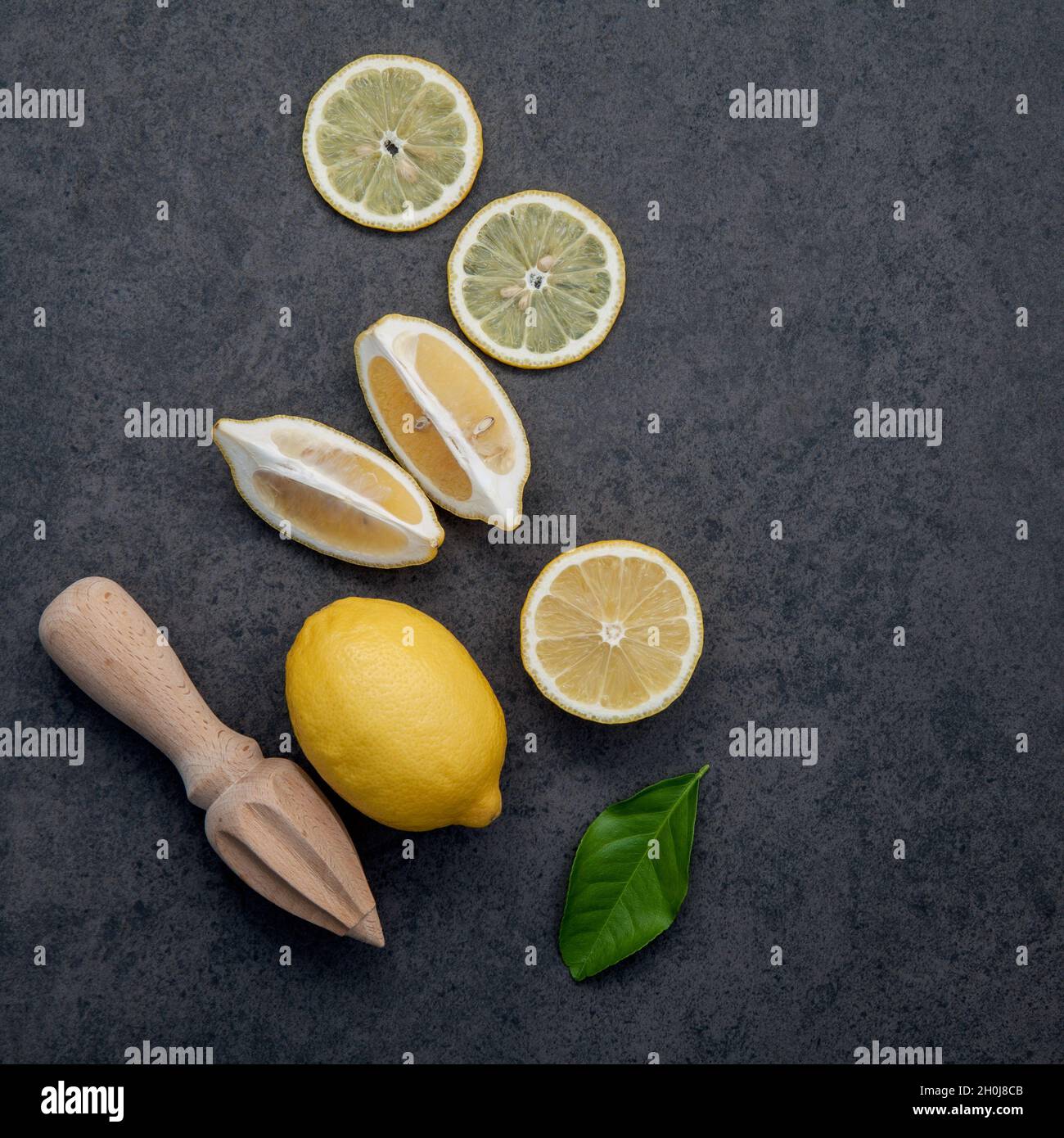 Fresh lemons and lemons leaves on dark stone background. Fresh lemons ...
