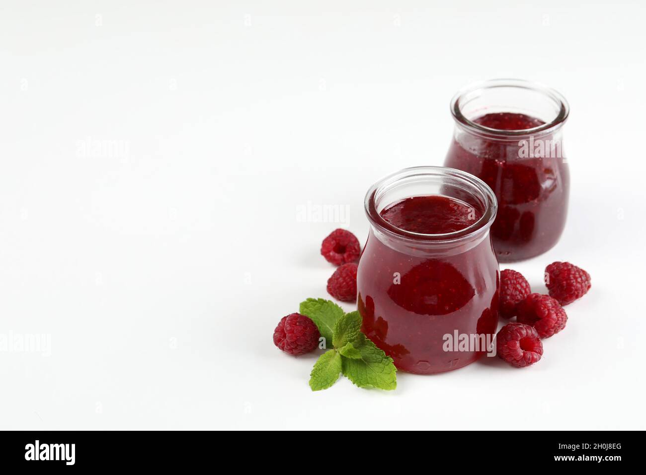 Jars of raspberry jam with ingredients on white background Stock Photo ...