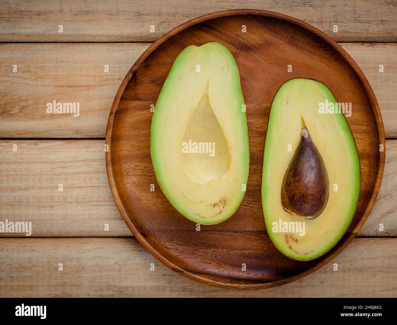 Healthy food concept.Closeup ripe avocado on wooden background. Halved ...