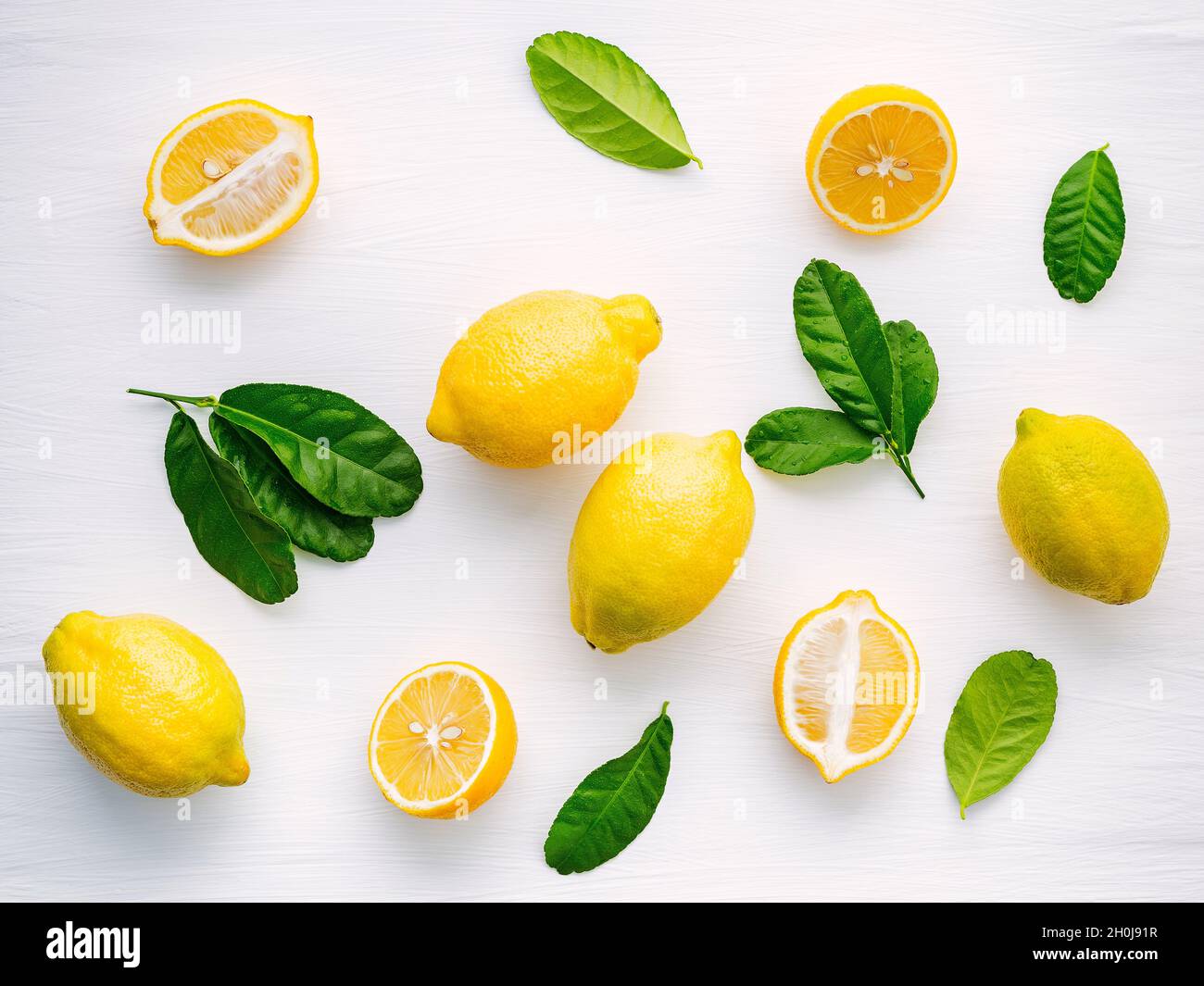 Fresh lemons and lemons leaves on white wooden background Stock Photo ...