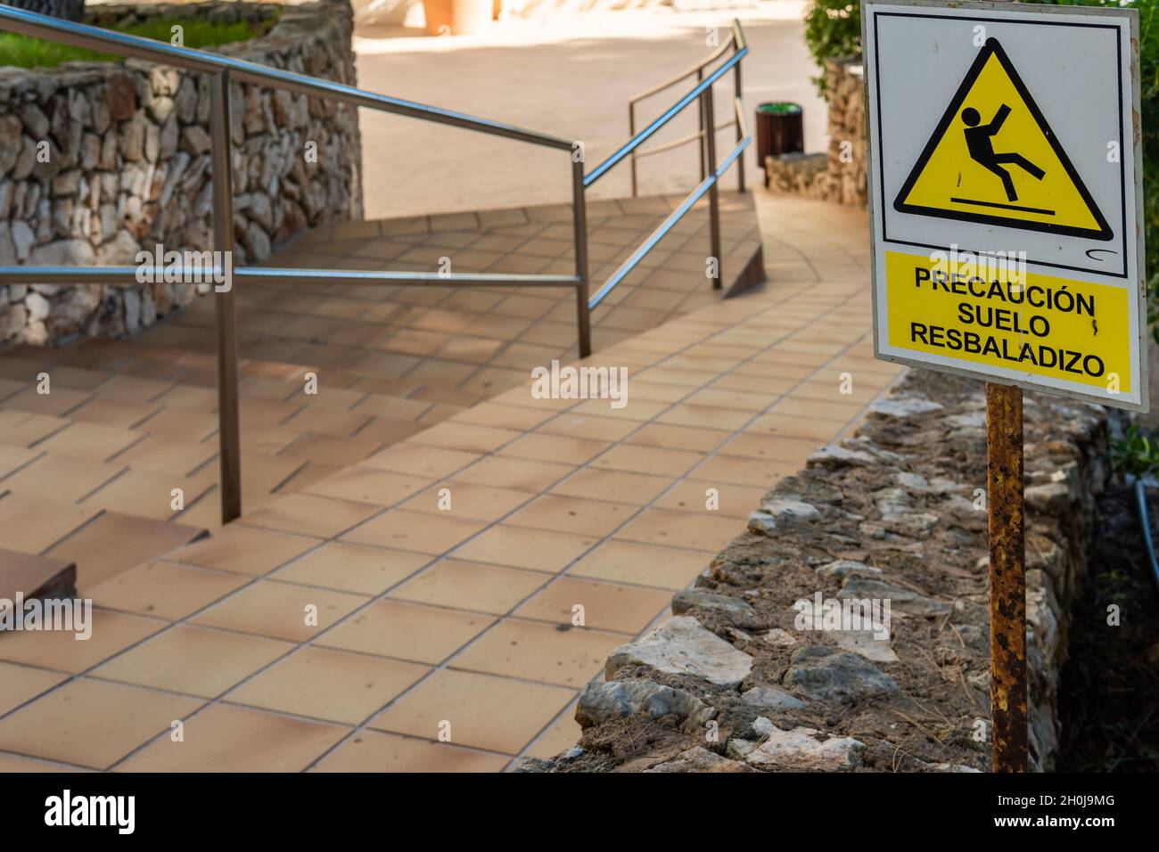 Close-up of the slippery ground caution sign, written in Spanish ...