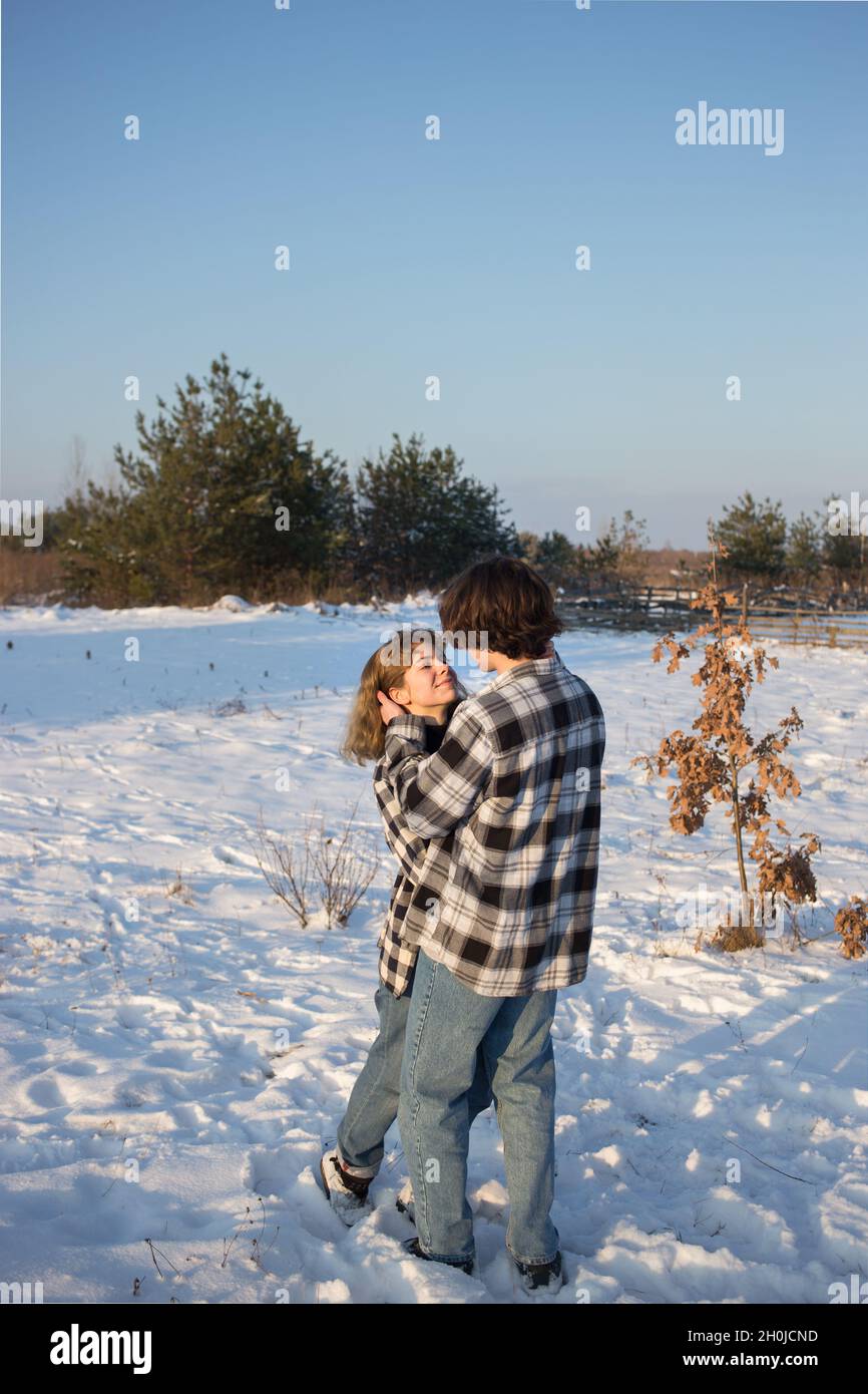 Winter walk happy young couple guy and girl in plaid shirts and jeans ...