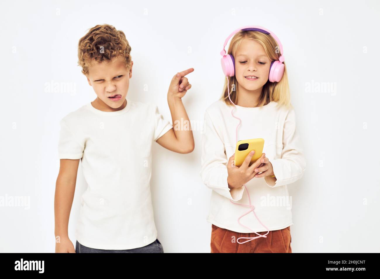 Two preschool children boy and girl smiling with phone in hand fashion ...