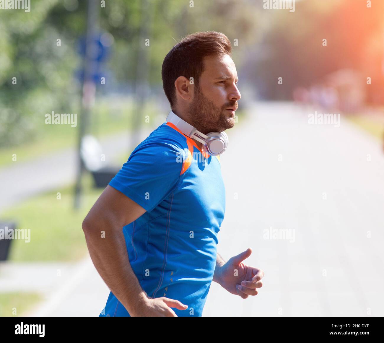 Satisfied handsome man running in park. Urban morning jogging Stock ...