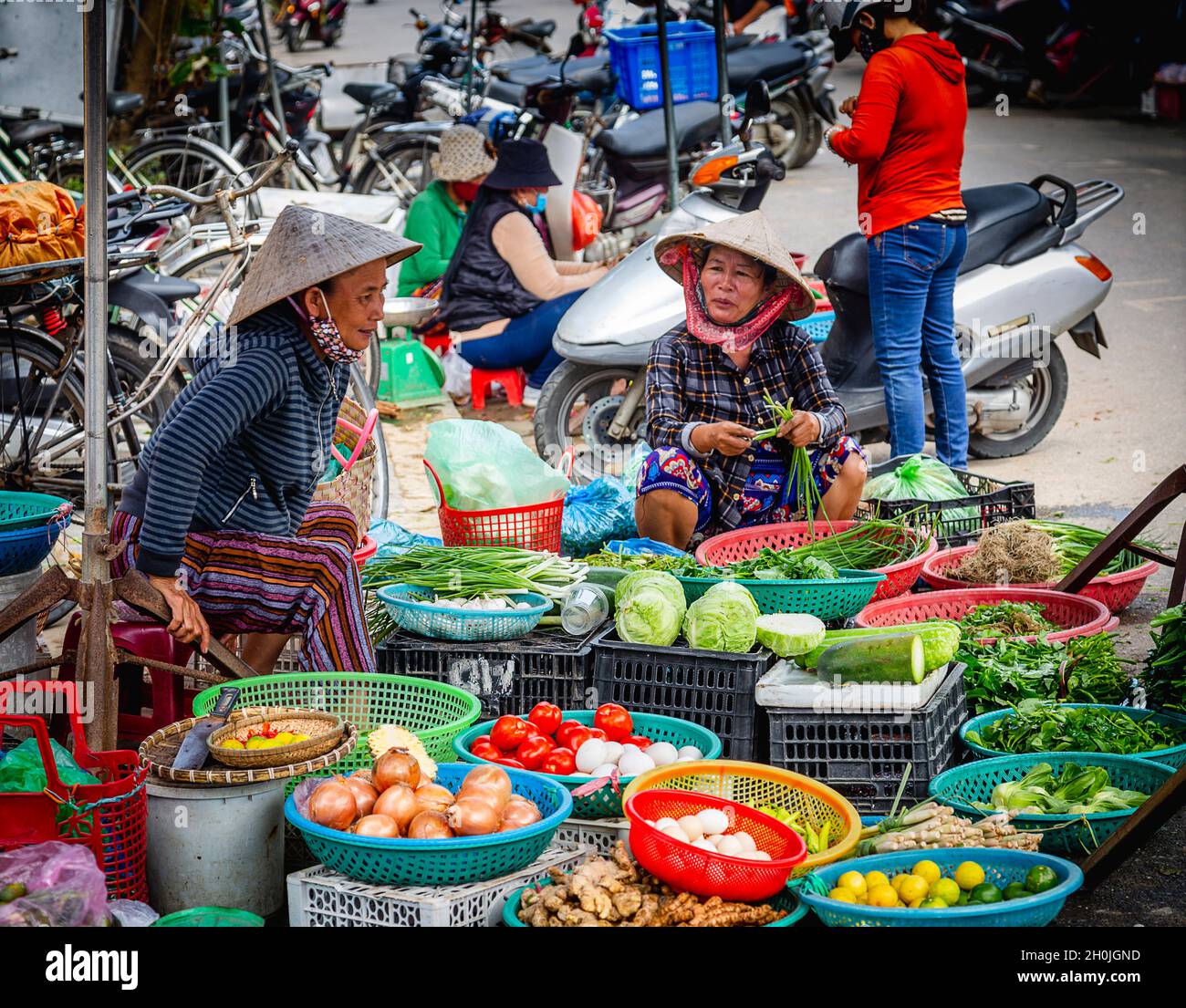 Two Vietnamese women talking while selling their produce at the open ...