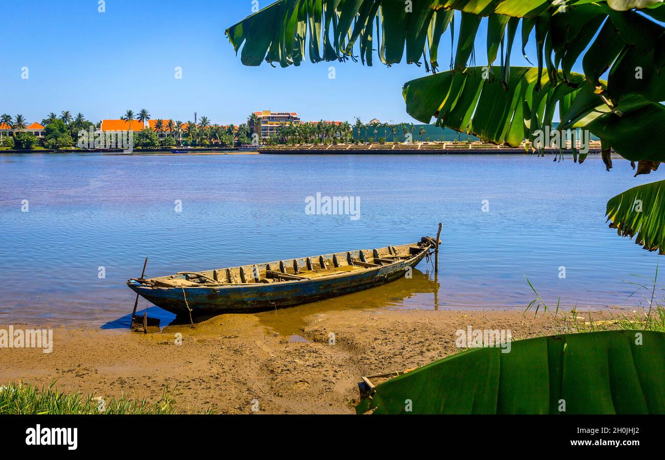 One empthy small boat sandwiched between green banana tree leaves with ...