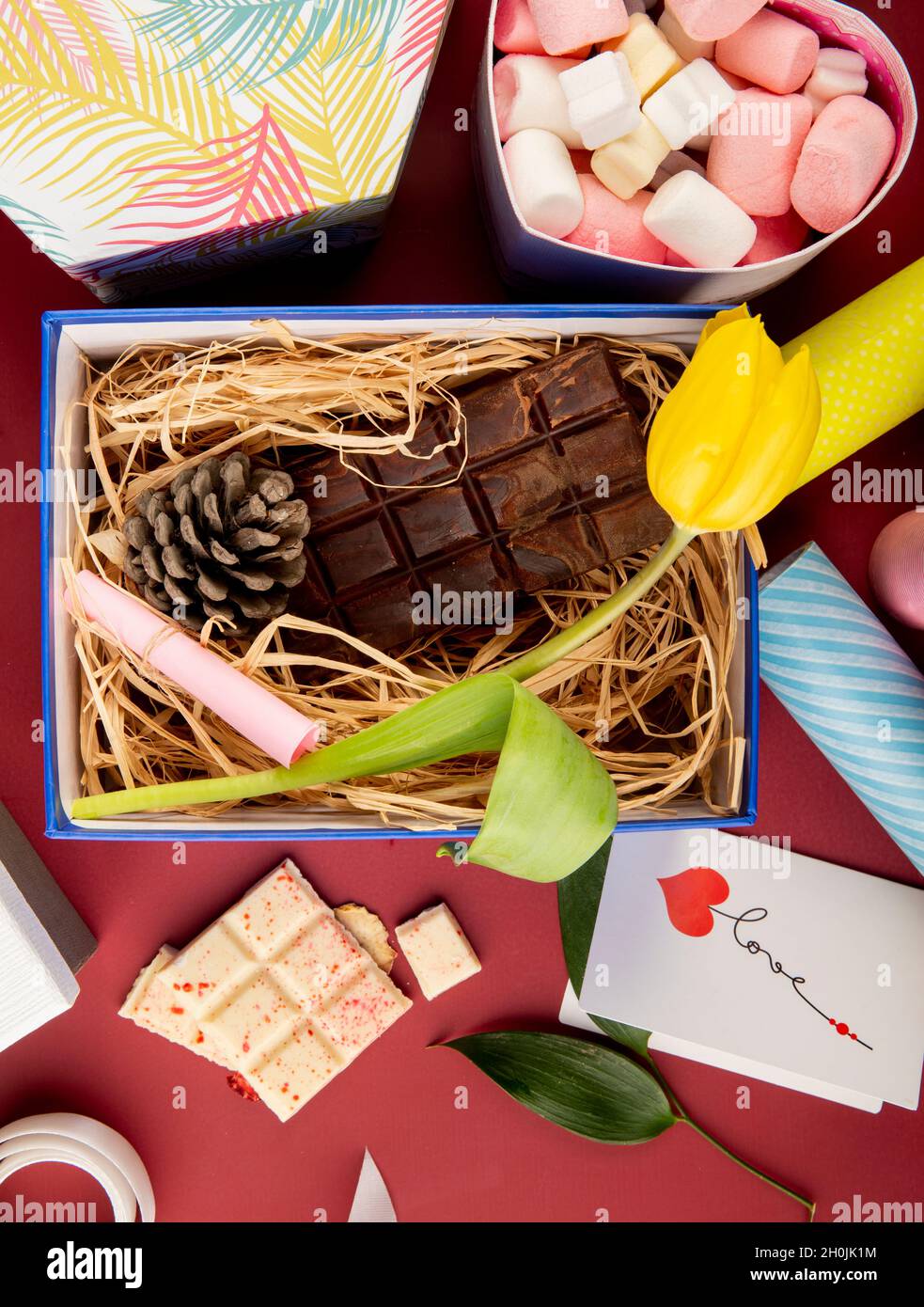 top view of an open present box with yellow color tulip flower , dark ...