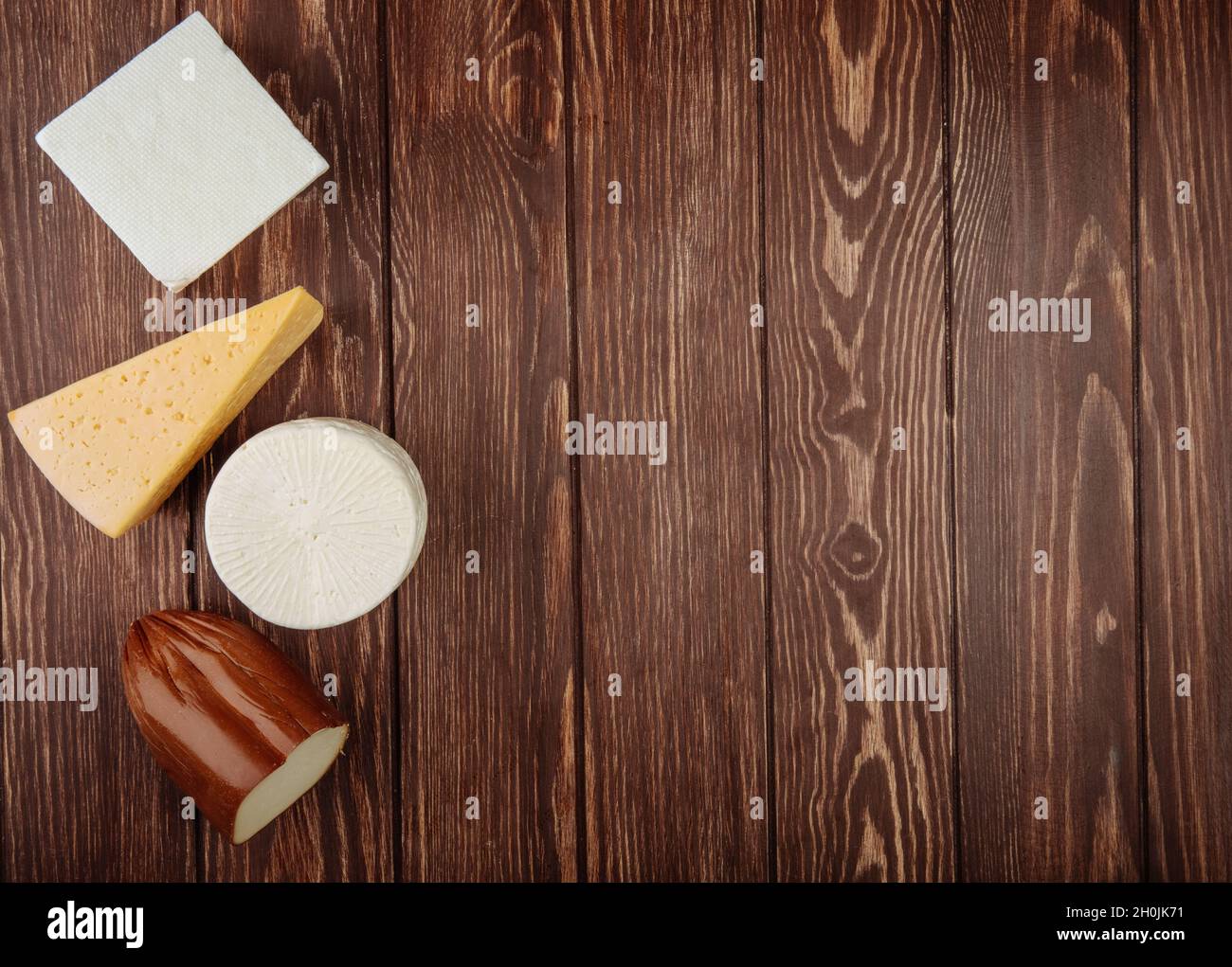 top view of different kind of cheese on rustic wooden background with ...