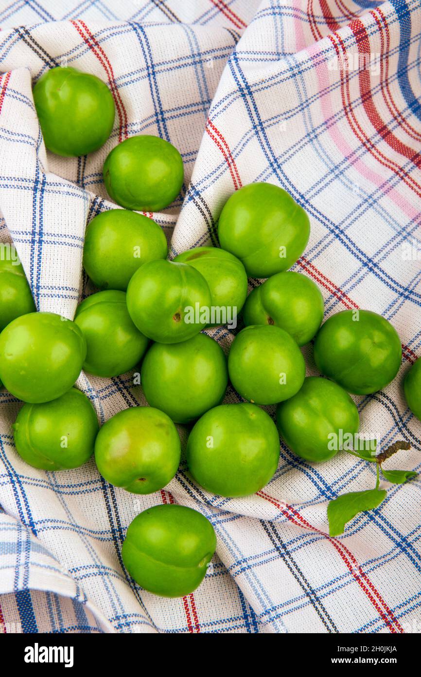 top view of sour green plums scattered on plaid fabric background Stock ...