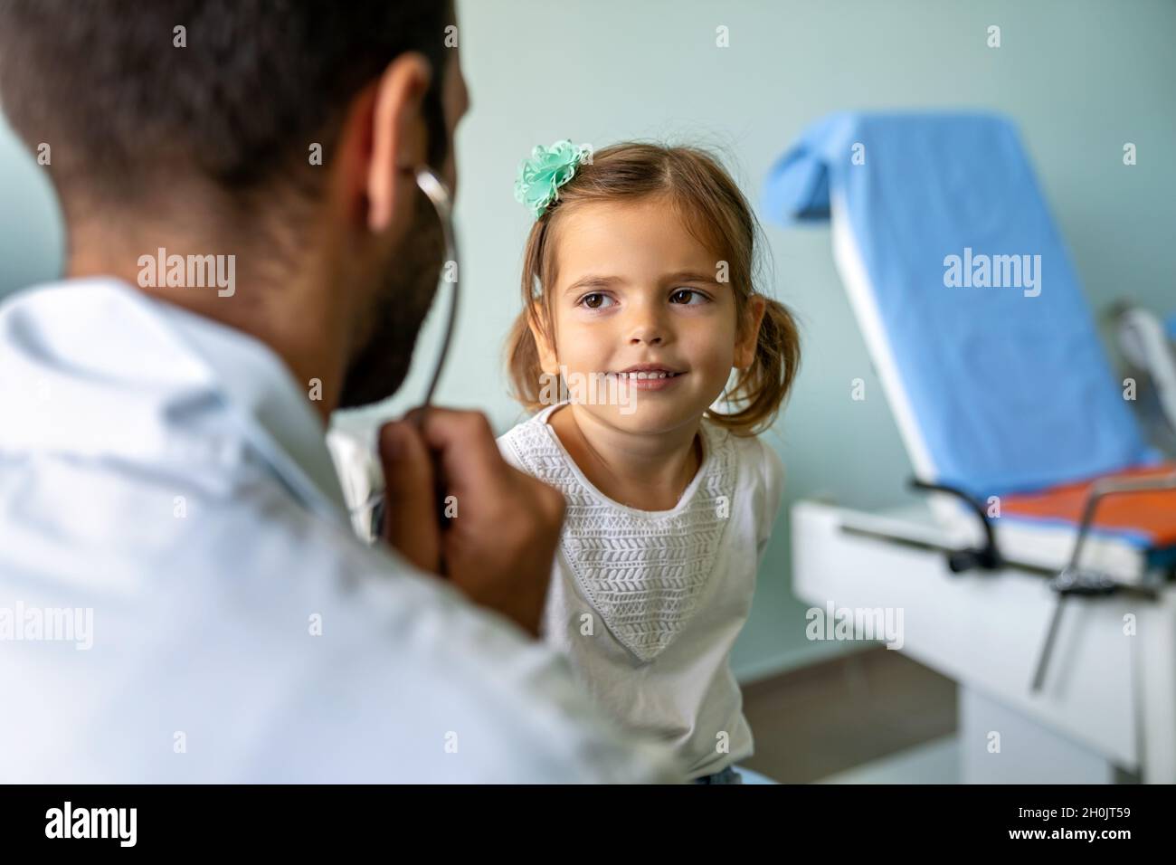 Doctor examines a child with stethoscope in examination room ...