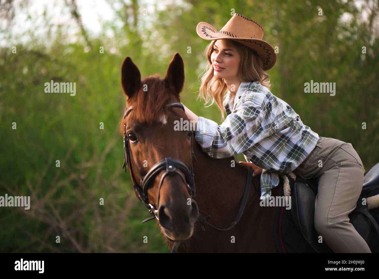 Beautiful girl in a hat riding a horse in countryside Stock Photo - Alamy