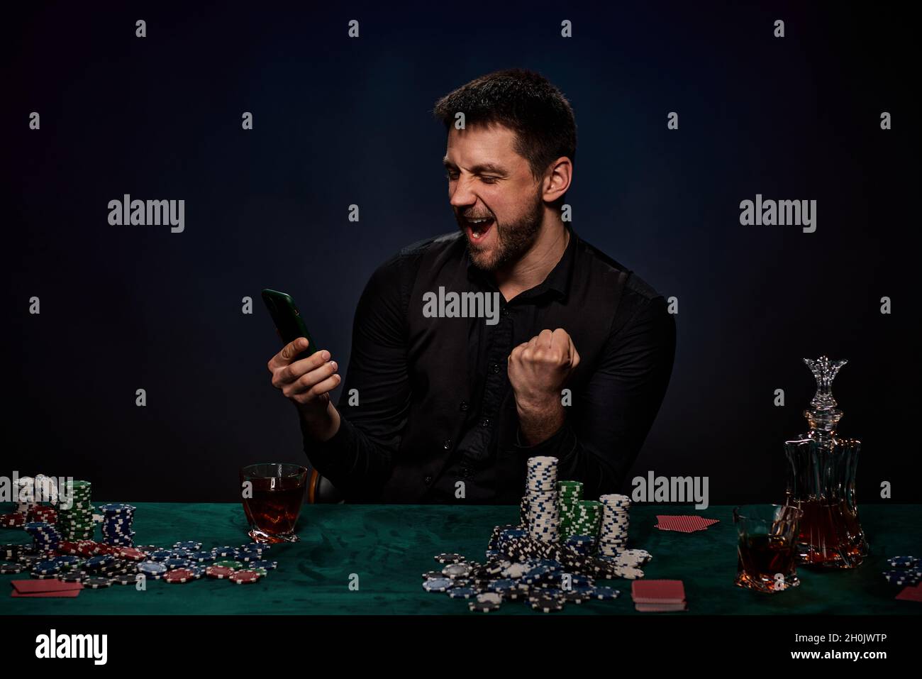Bearded casino player man playing poker on green table Stock Photo - Alamy