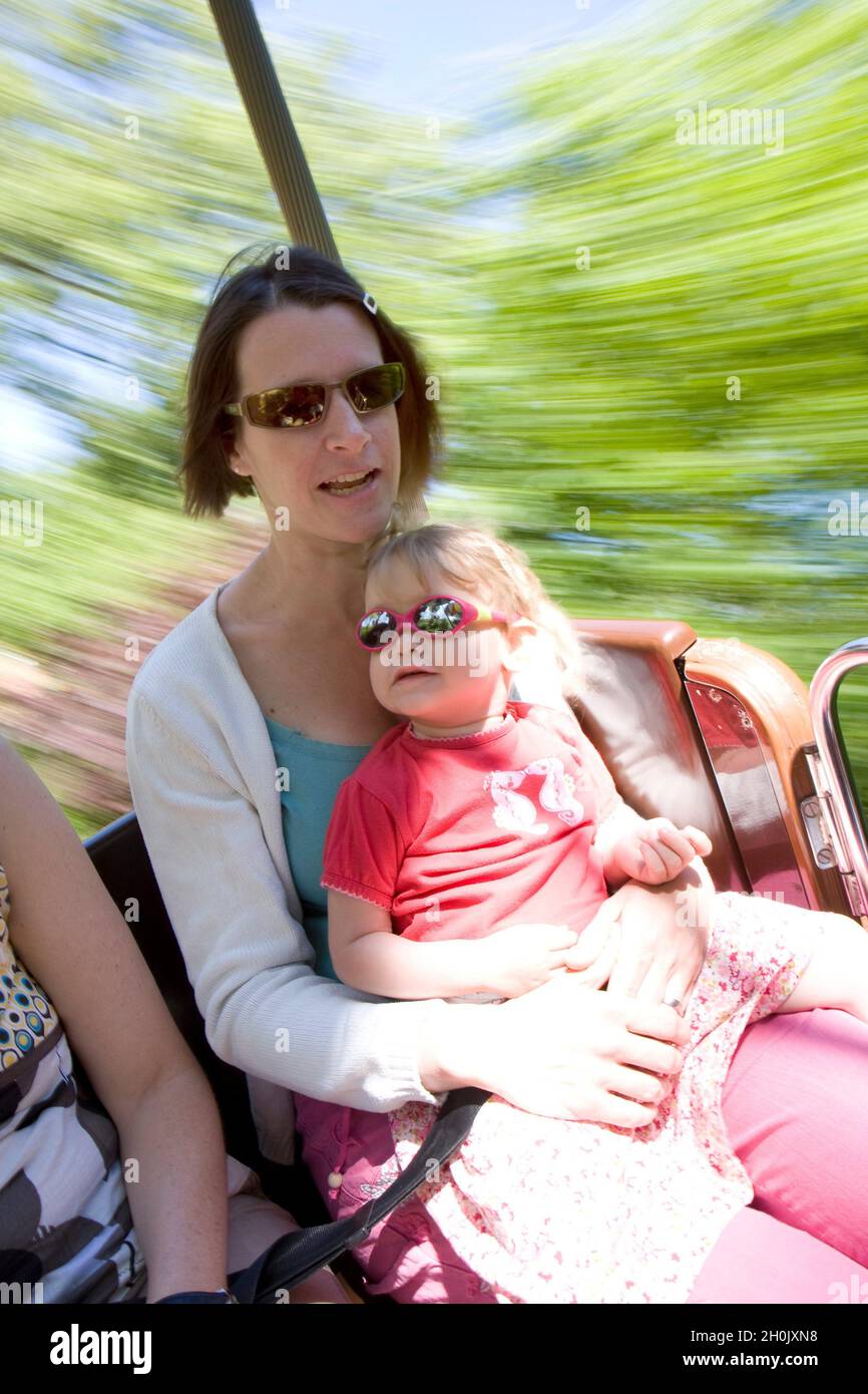 mother driving carousel with little daughter Stock Photo - Alamy
