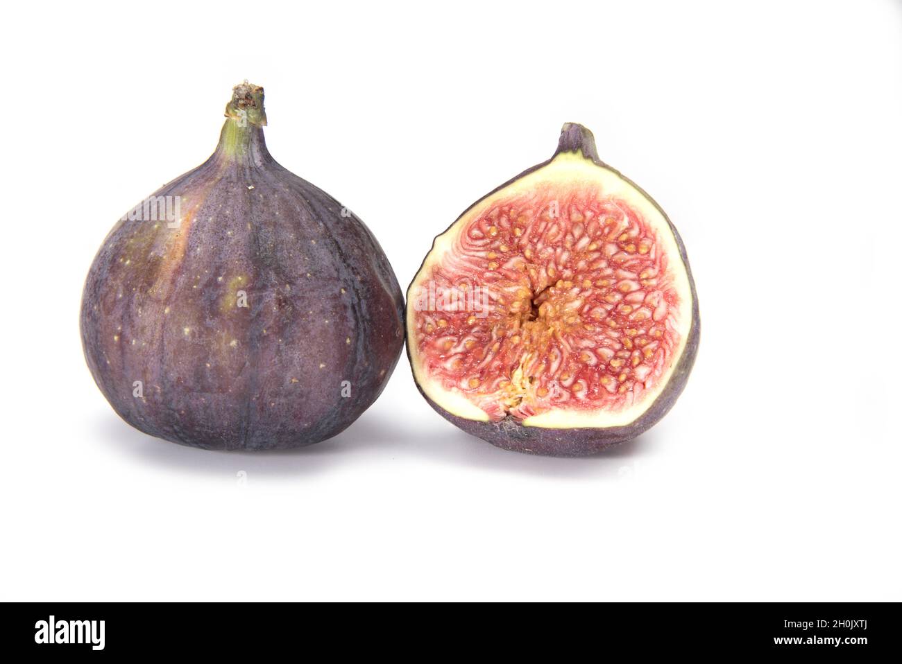 Close up of ripe figs with one cut in the middle and showing the inside ...