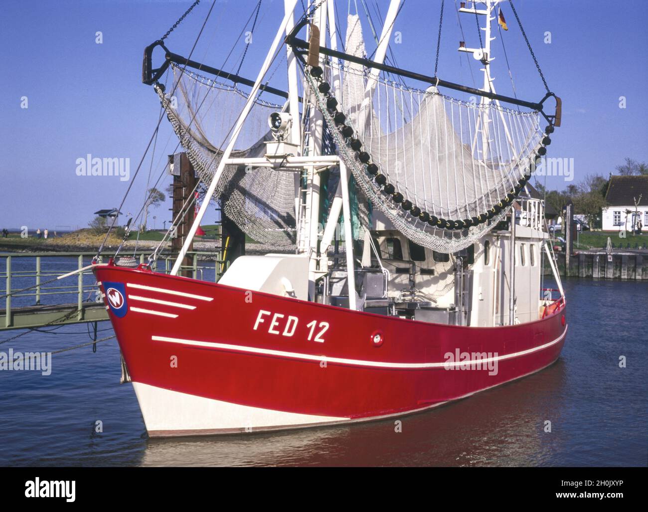 Red bascule bridge with raised fishing nets at the pier of ...