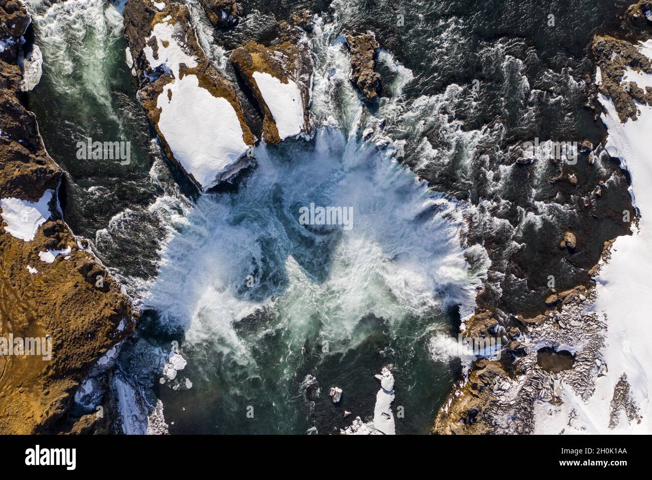 Aerial view of Godafoss waterfall, snowy shore and river. Iceland in ...