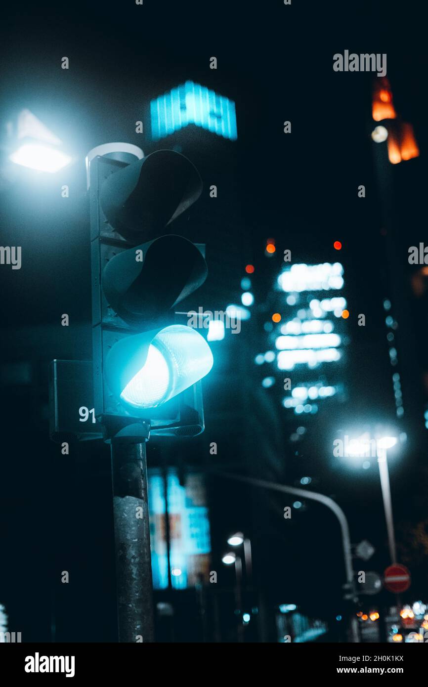 Urban view of blue neon pedestrian passing traffic light on the road at ...