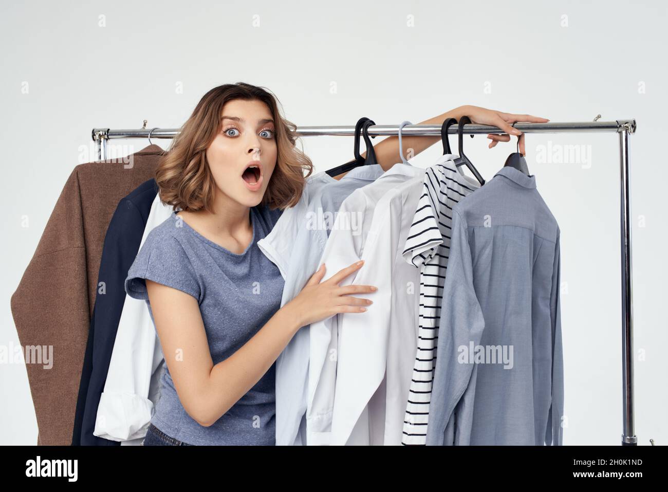 pretty woman selection of clothes near the wardrobe light background ...