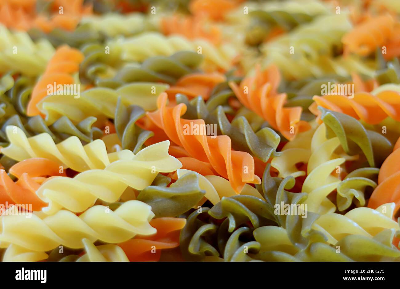 Closeup a pile of three-color spiral shaped fusilli pasta for ...