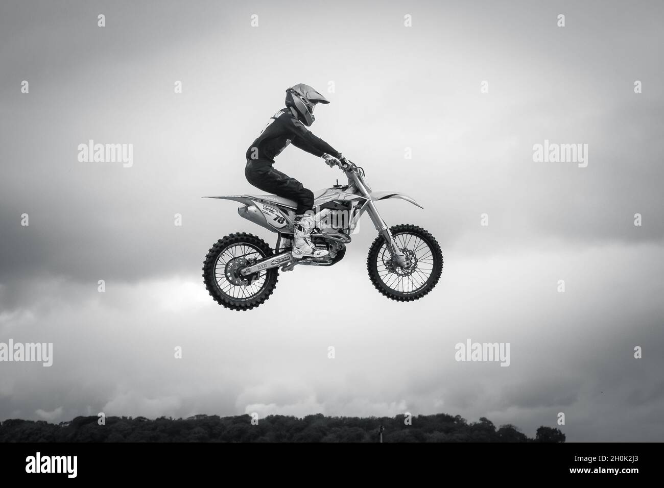 A black and white picture man performing a stunt on a motorcycle ...