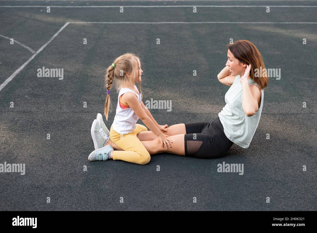 Mother and daughter go in for sports outdoors. Caucasian woman and ...