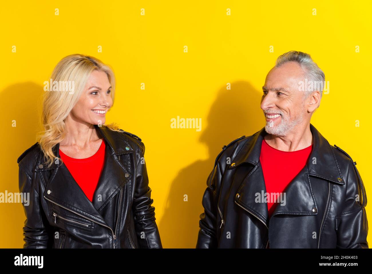 Portrait of two attractive cheerful cool grey-haired spouses looking at ...