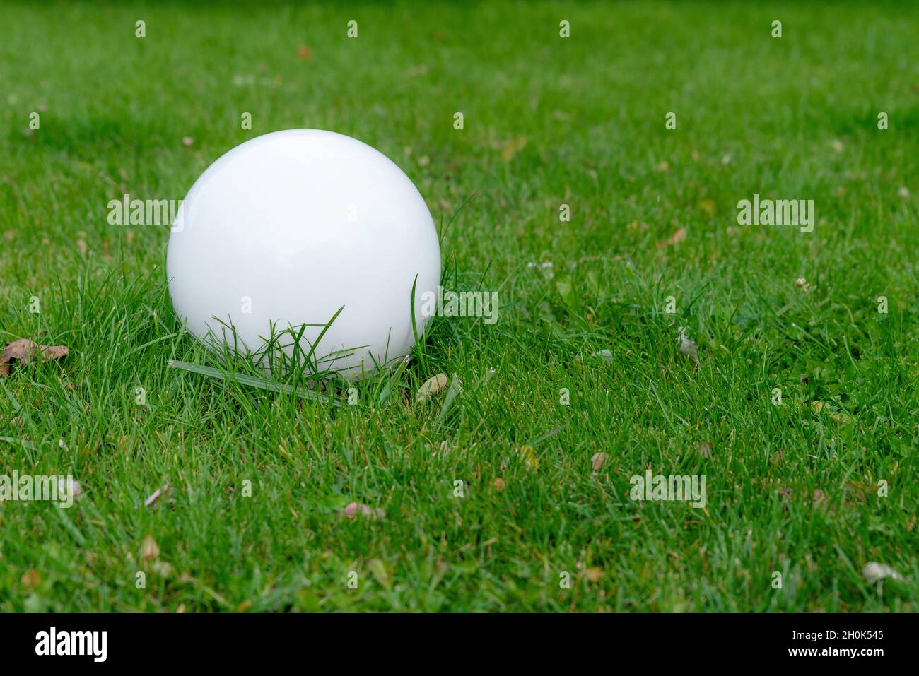 Lighting ground street lamp in the shape of a ball mounted on a green ...