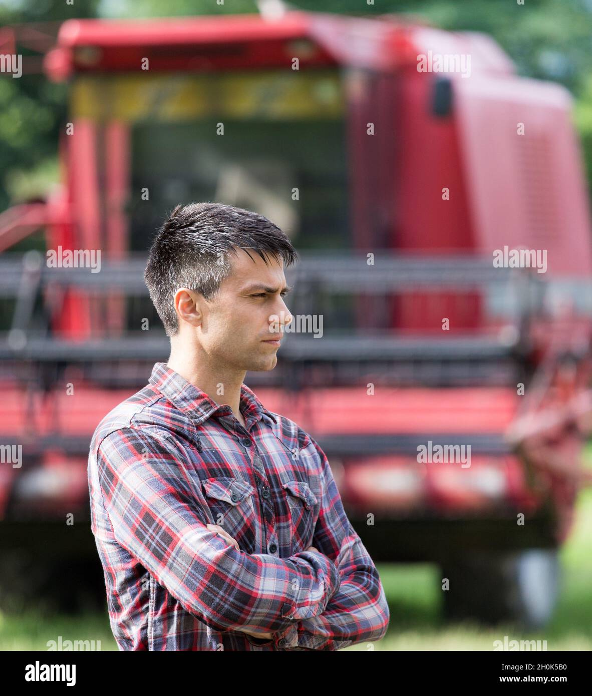 Confident handsome farmer standing with crossed arms in front of ...