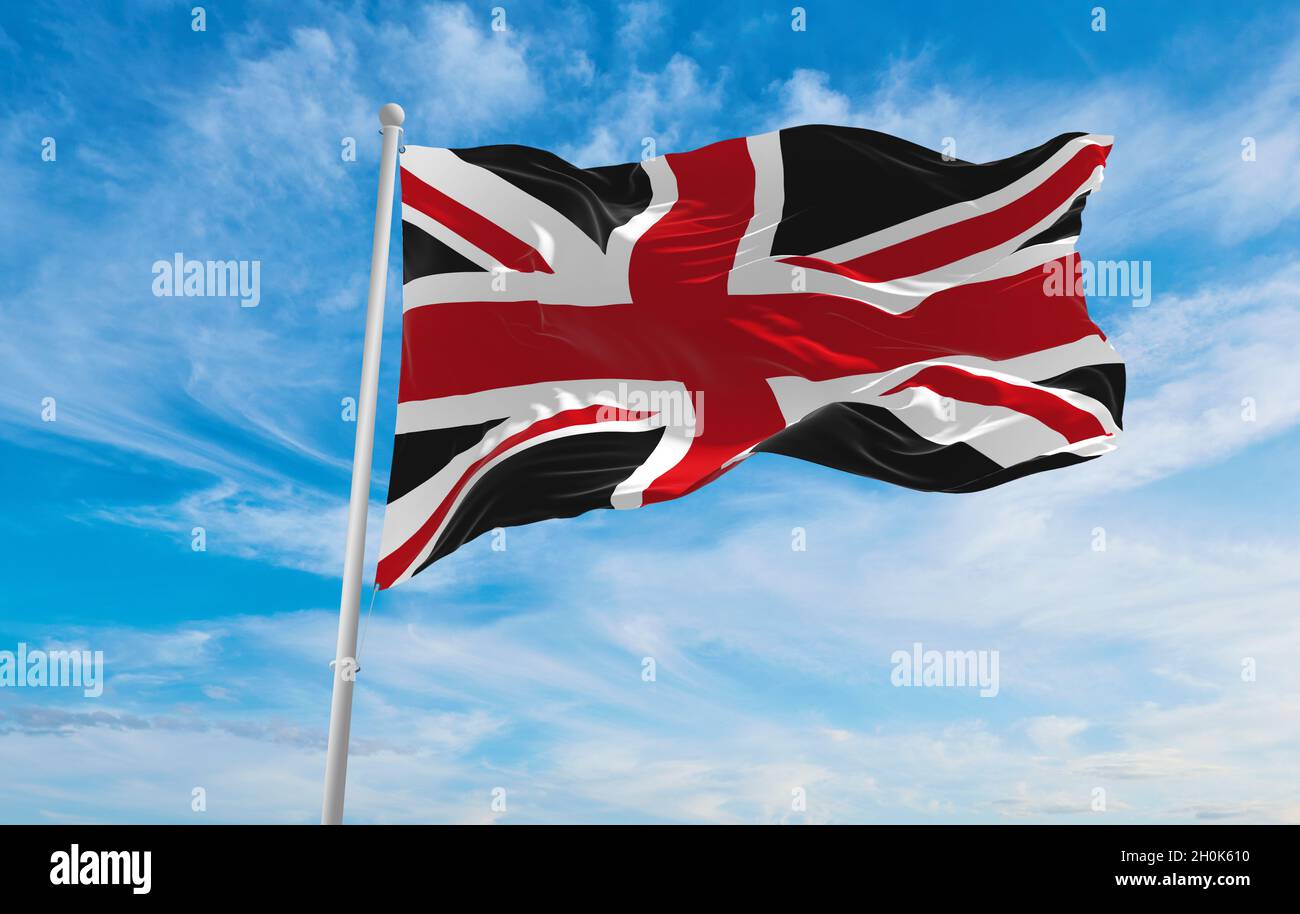 United Kingdom black and red flag at cloudy sky background on sunset ...
