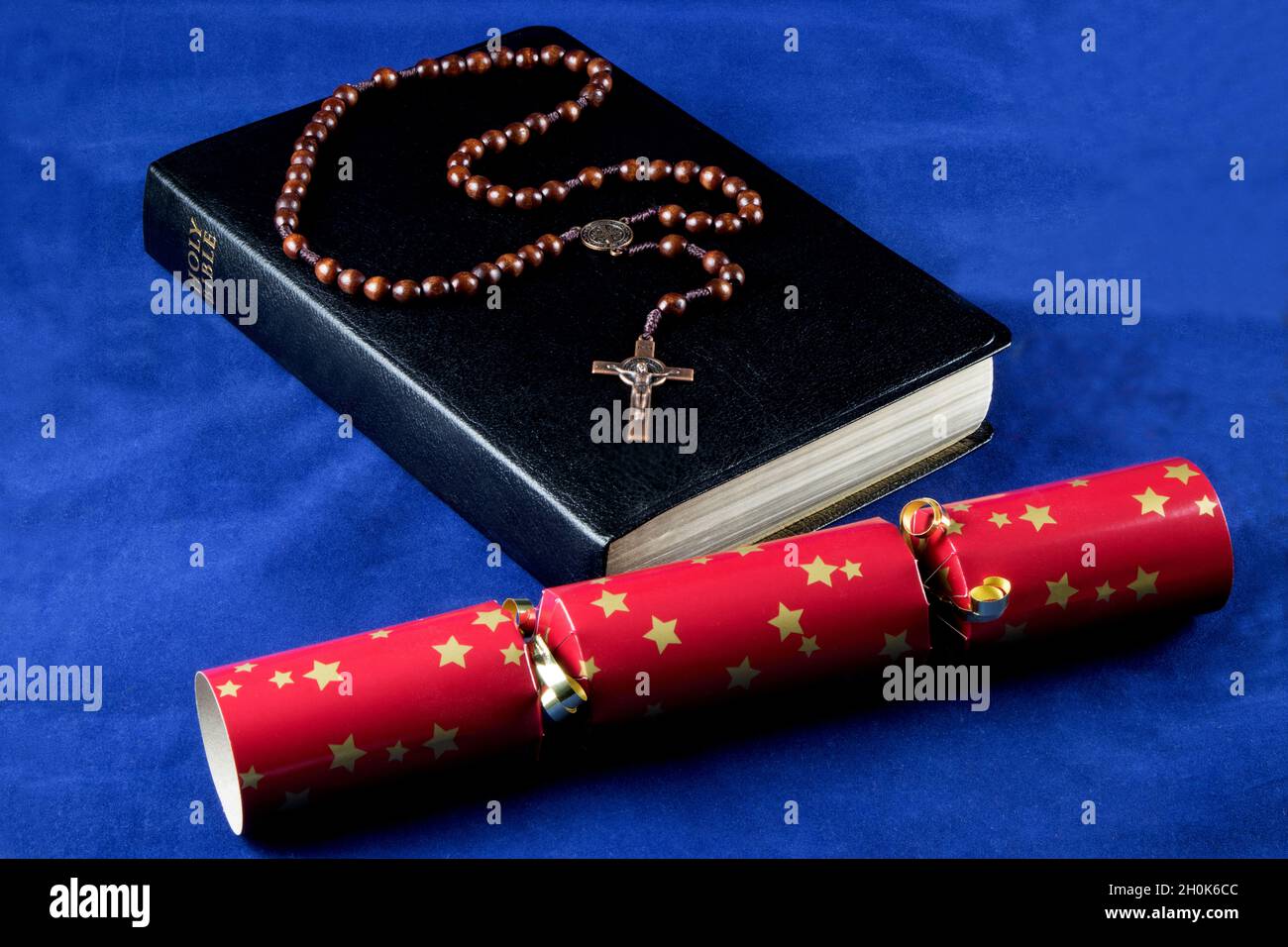 Christian bible with rosary and christmas cracker on a blue cloth ...