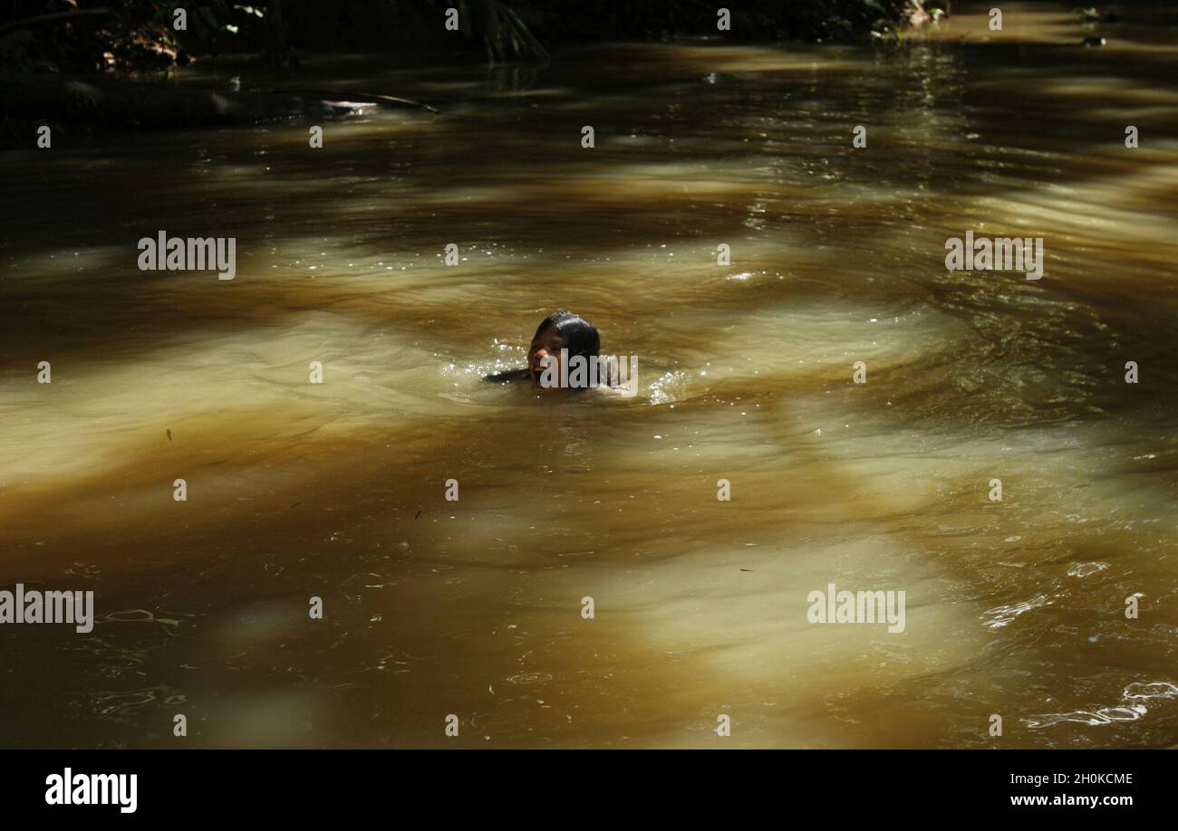 A woman from the ethnic Huaorani community, bathing in the river. The ...