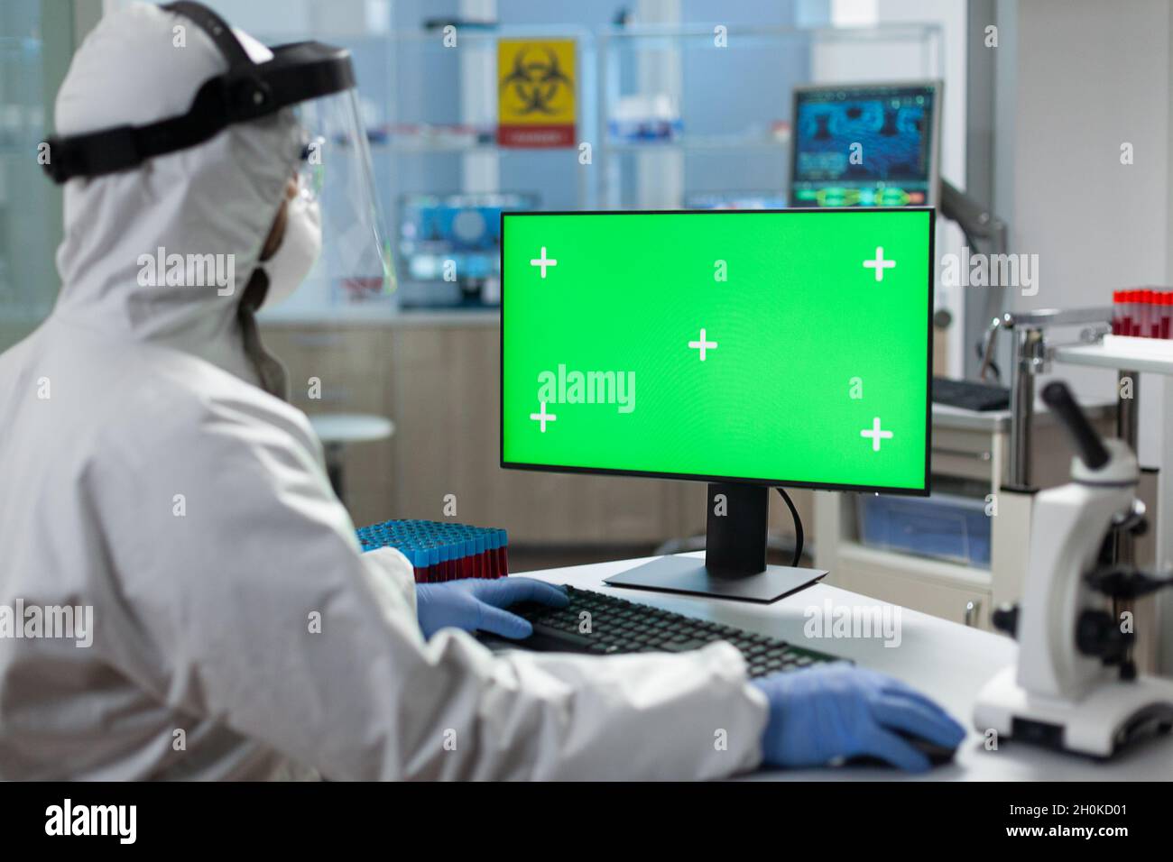 Biologist man with protection ppe medical suit looking at mock up green ...