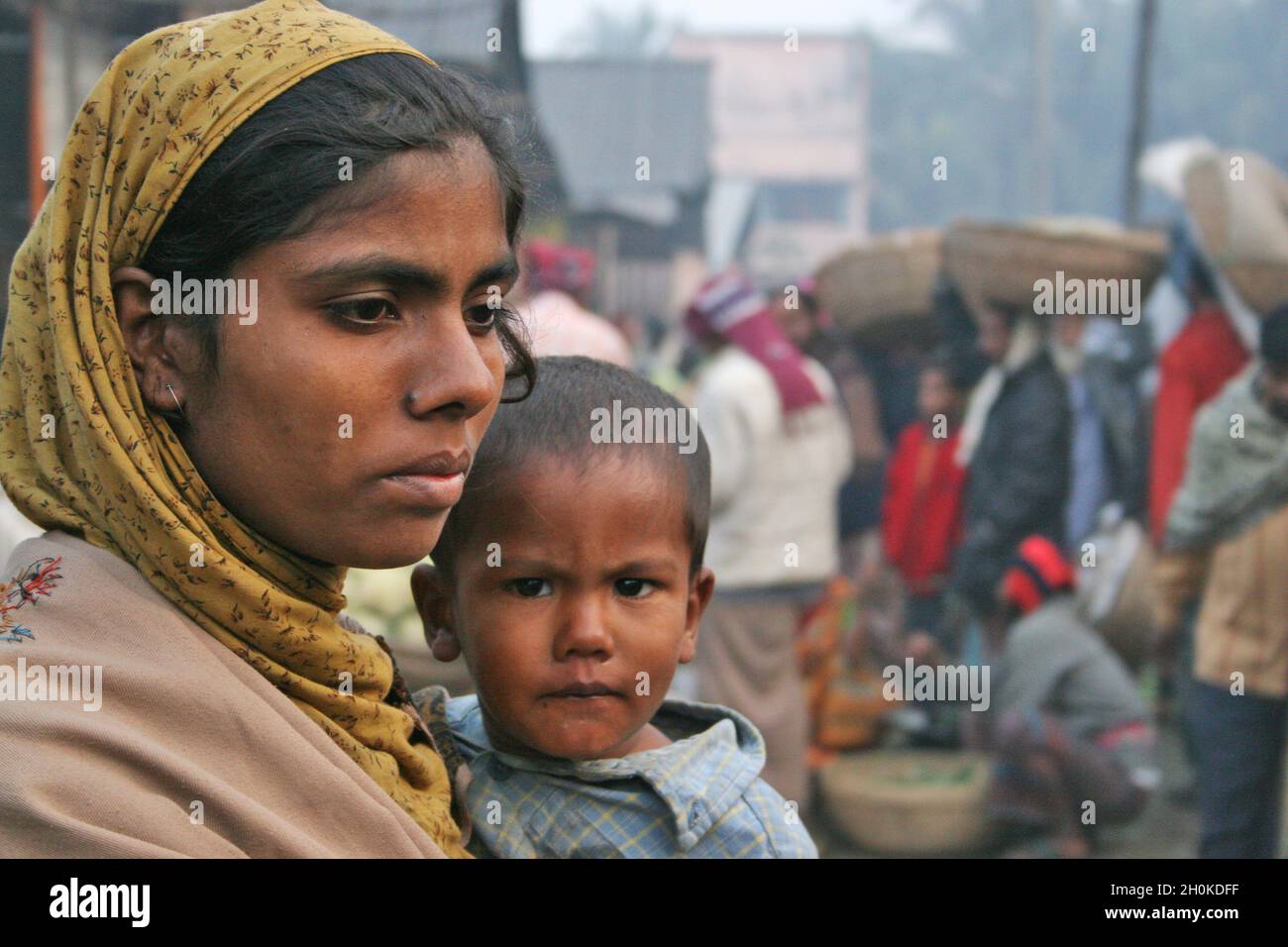 A mother and child come to collect rejected vegetable in a vegetable ...