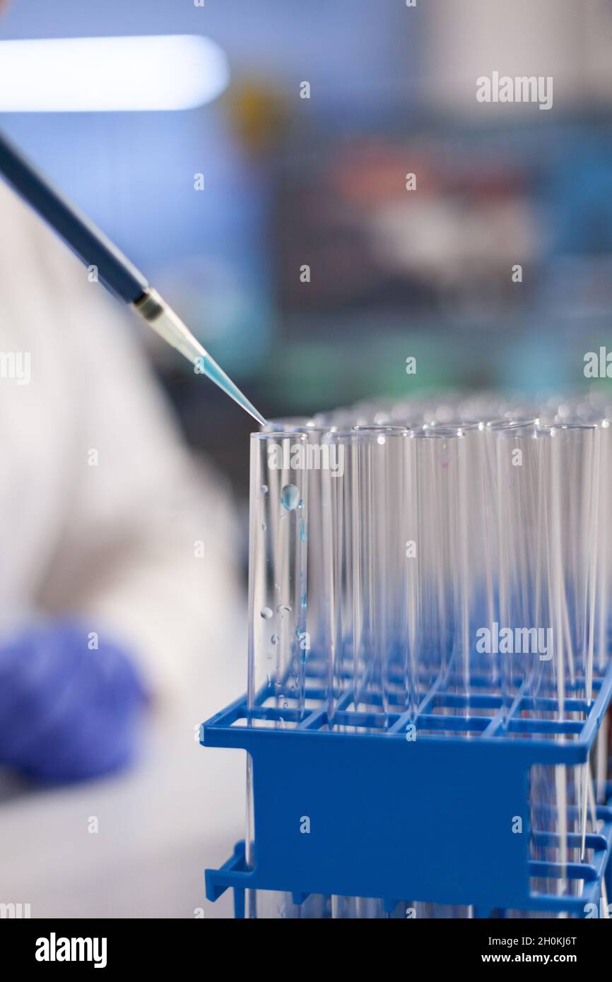 Closeup of chemist researcher dropping solution in transparent test ...