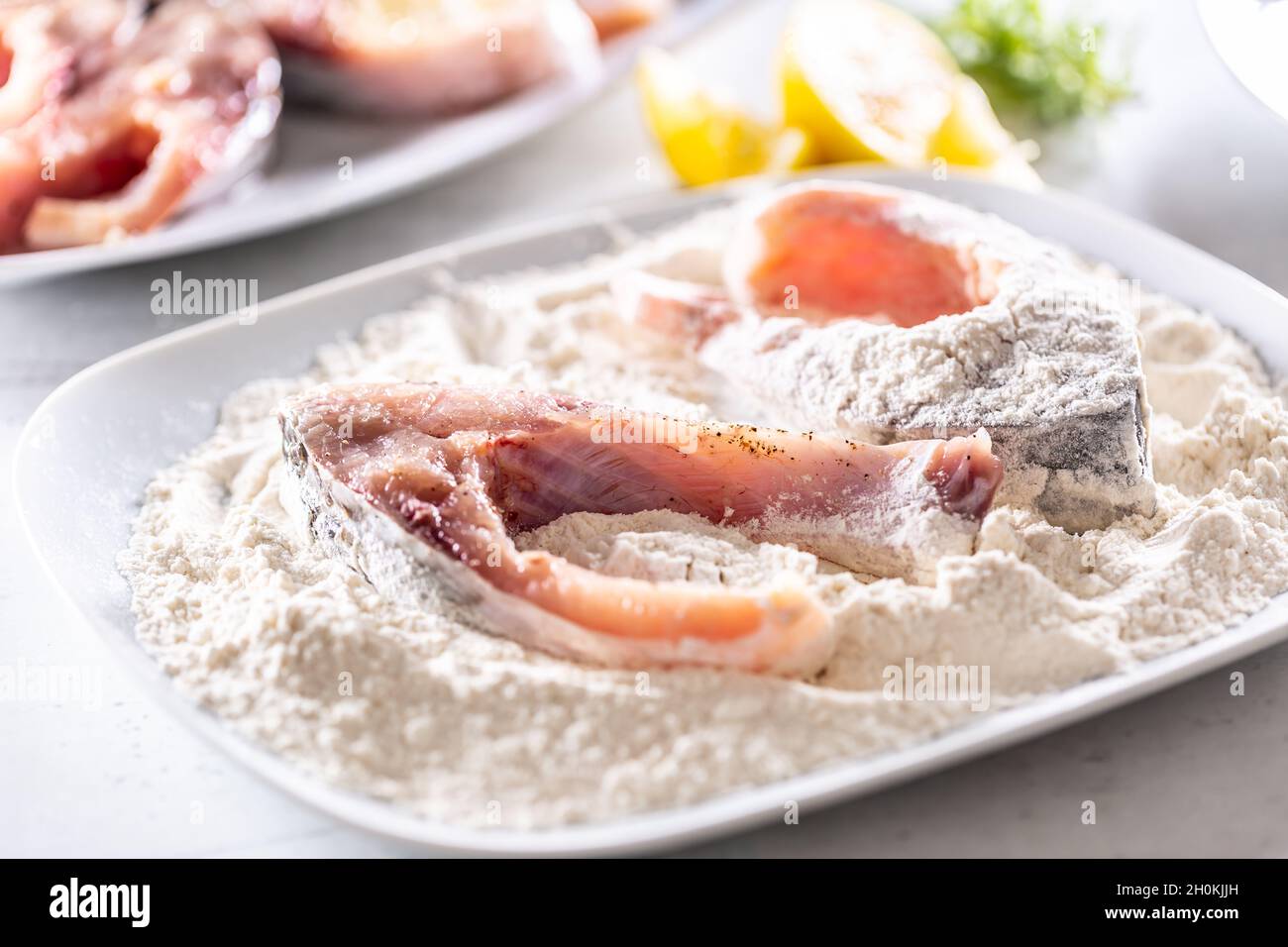 Preparation of fresh fish before frying by wrapping in flour Stock ...