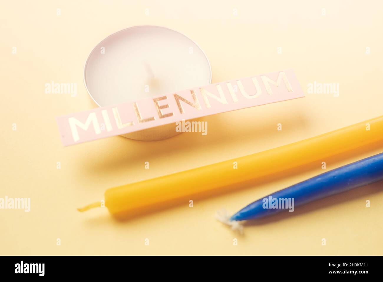 Paper with text millennium and different candles on yellow table Stock ...