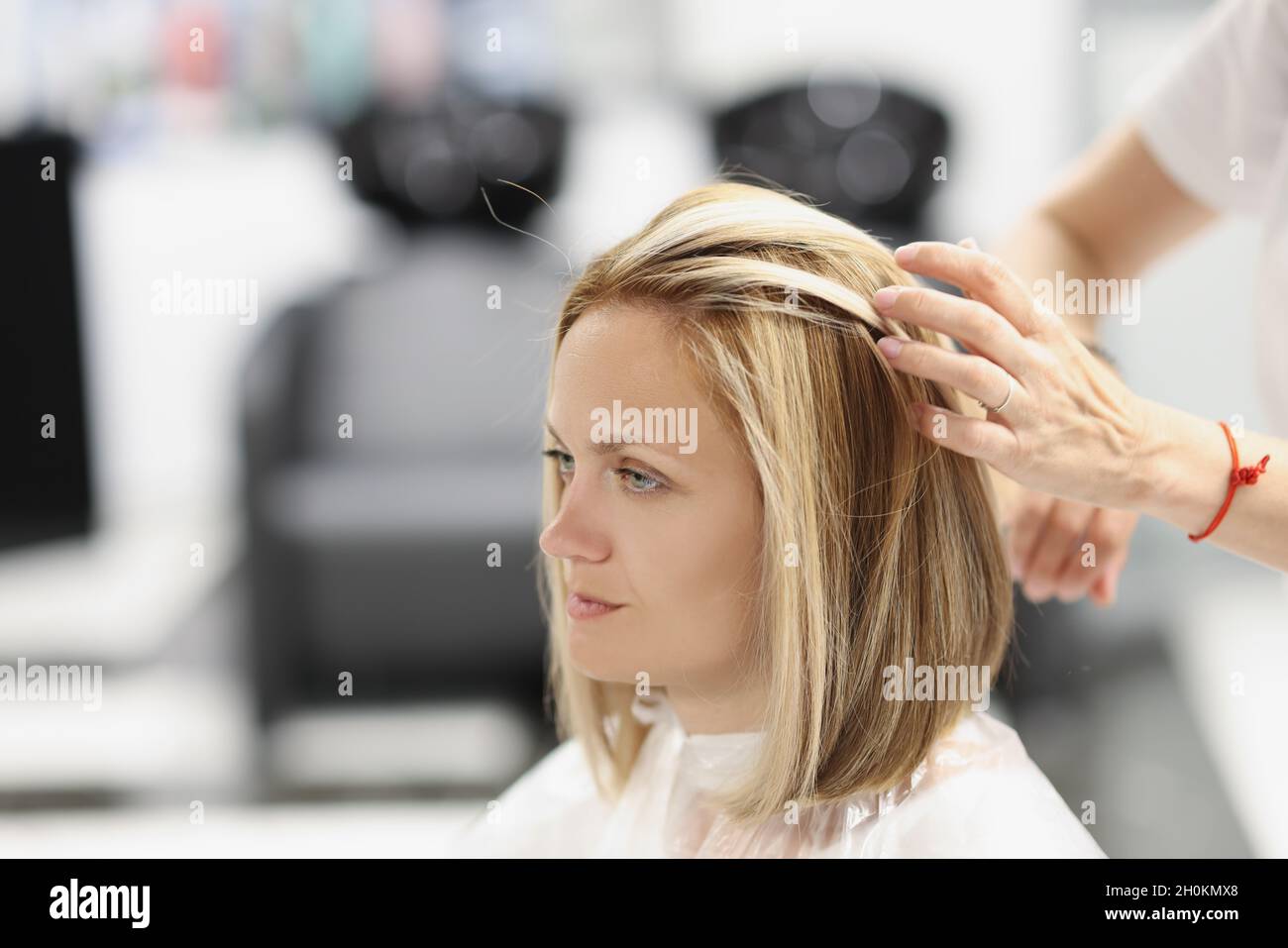 Hairdresser making hair styling to woman client in beauty salon Stock ...